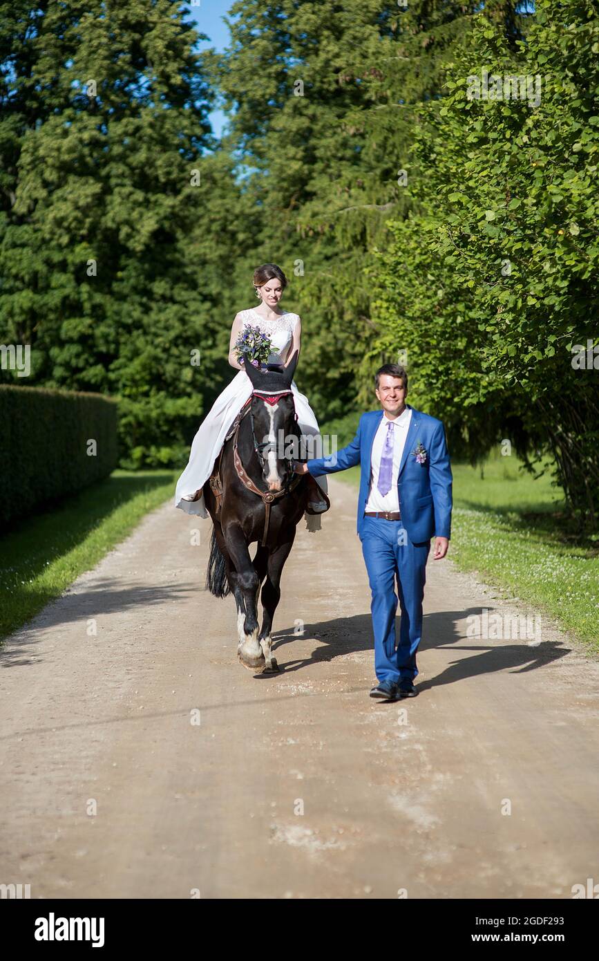 Wedding outdoor portrait. The beautiful attractive bride is ridding the ...
