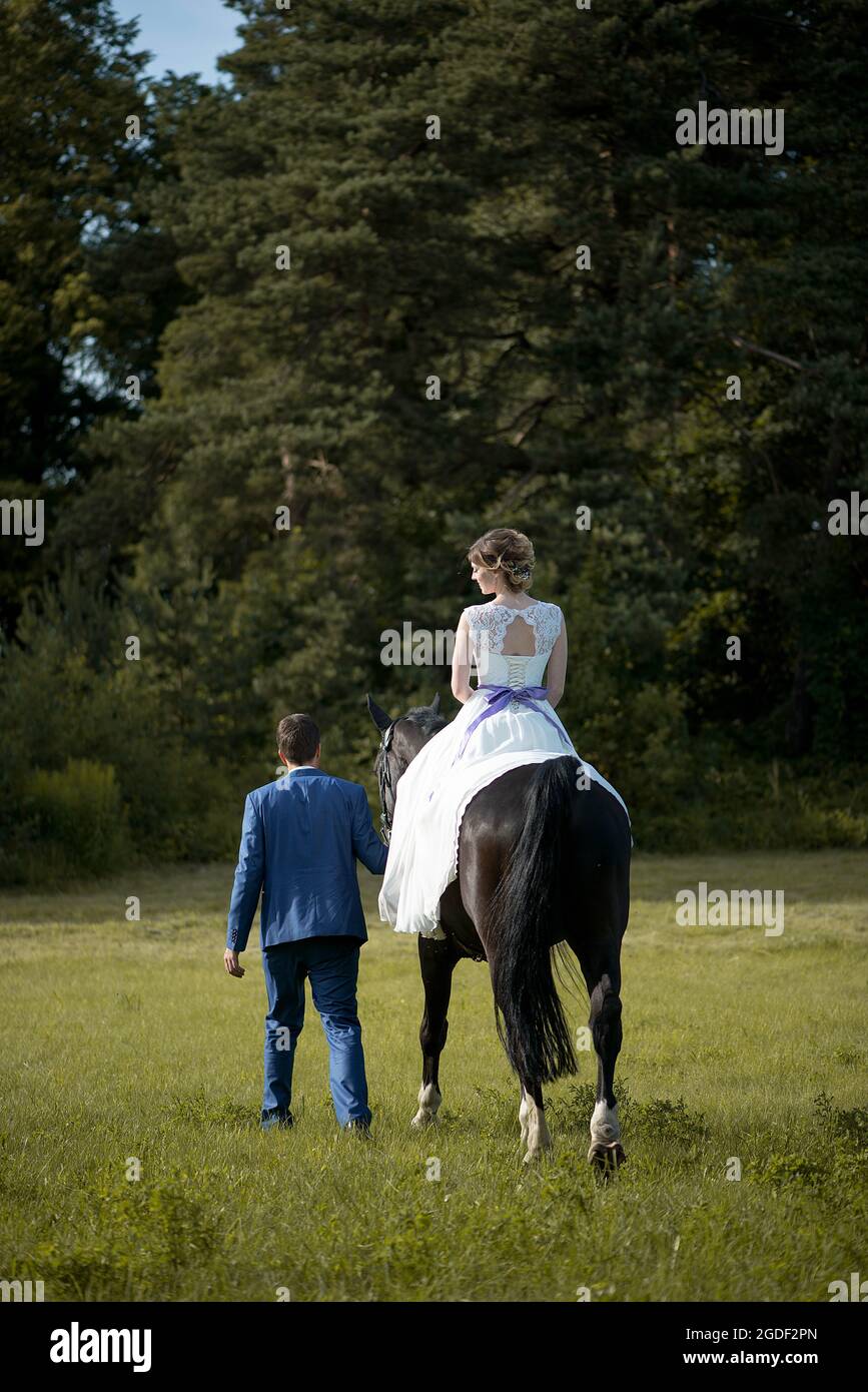 Wedding outdoor portrait. The beautiful attractive bride is ridding the ...