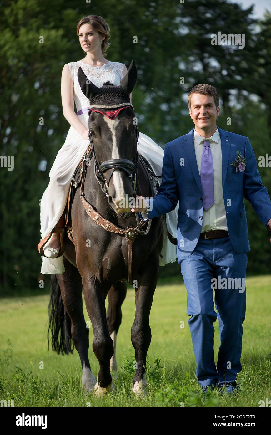 Wedding outdoor portrait. The beautiful attractive bride is ridding the ...
