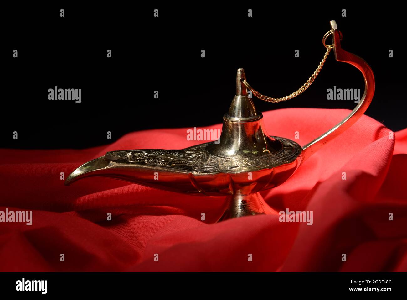 Magic lamp on table on black background Stock Photo - Alamy