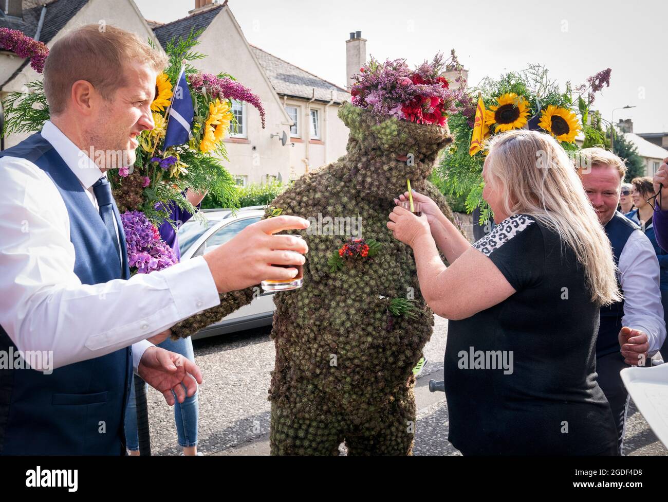 Burryman Andrew Taylor is gets a nip of whisky using a straw from ...
