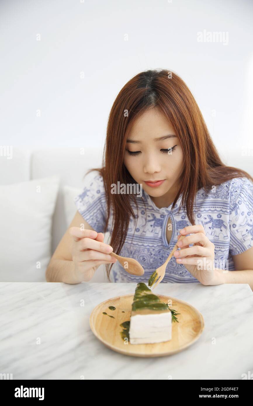 Young Asian Woman eating Green tea crape cake sweet food Stock Photo ...