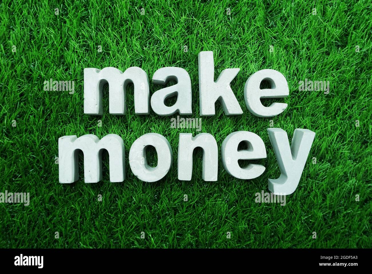 Make Money made from concrete alphabet top view on green grass Stock ...