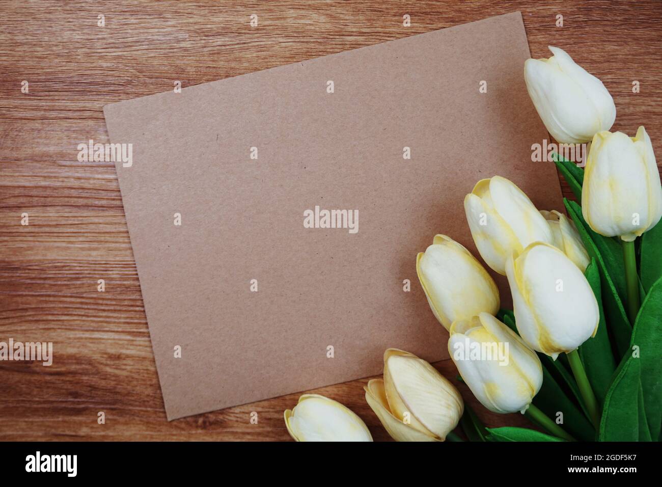Empty paper craft with tulip flower bouquet Top view on wooden ...