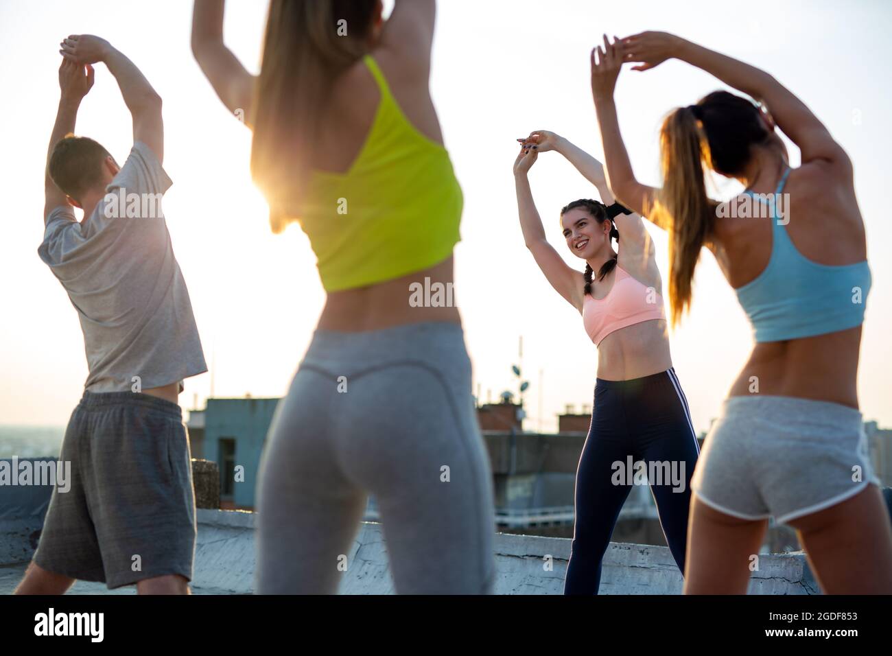 Group of happy fit friends exercising together outdoor Stock Photo - Alamy
