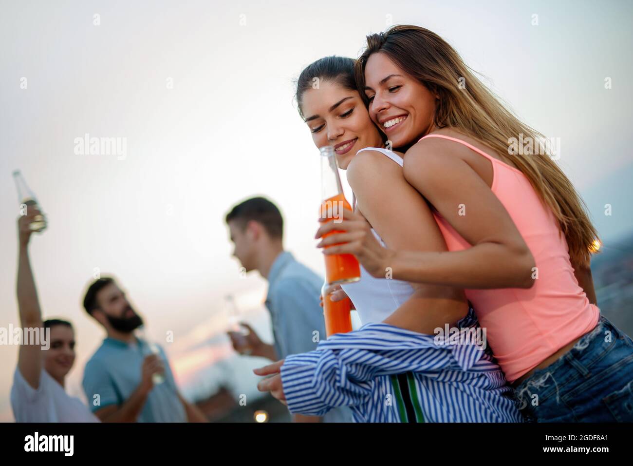 Friends having fun and drinking cocktails outdoor on a rooftop party ...