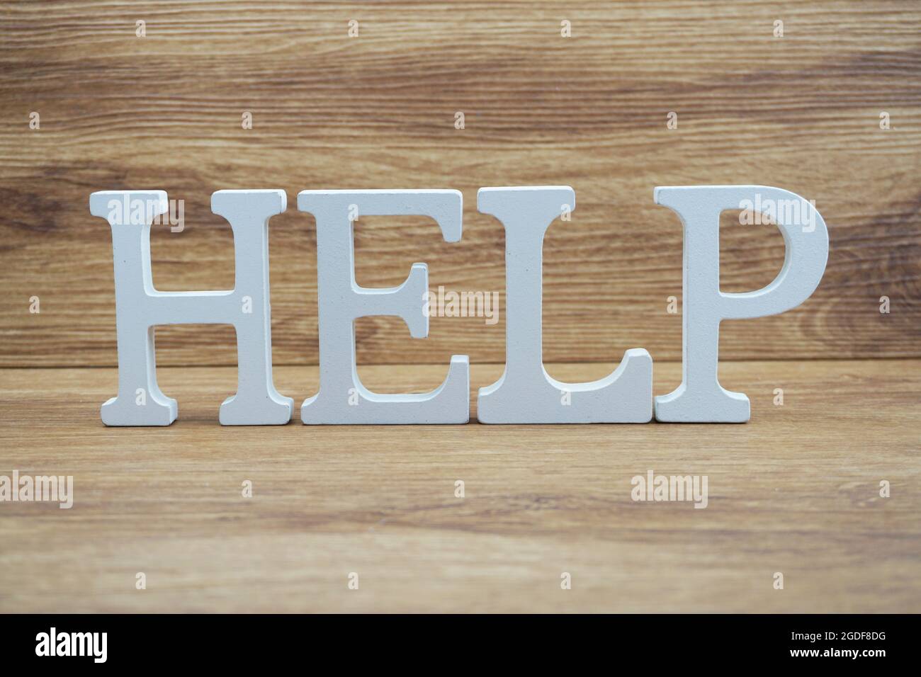 Help alphabet letters on wooden background Stock Photo - Alamy