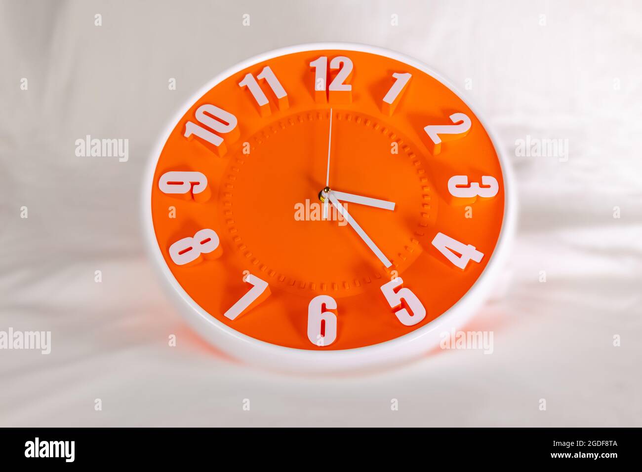 Orange Wall Clock on white blur background. Shadows over the clock face ...