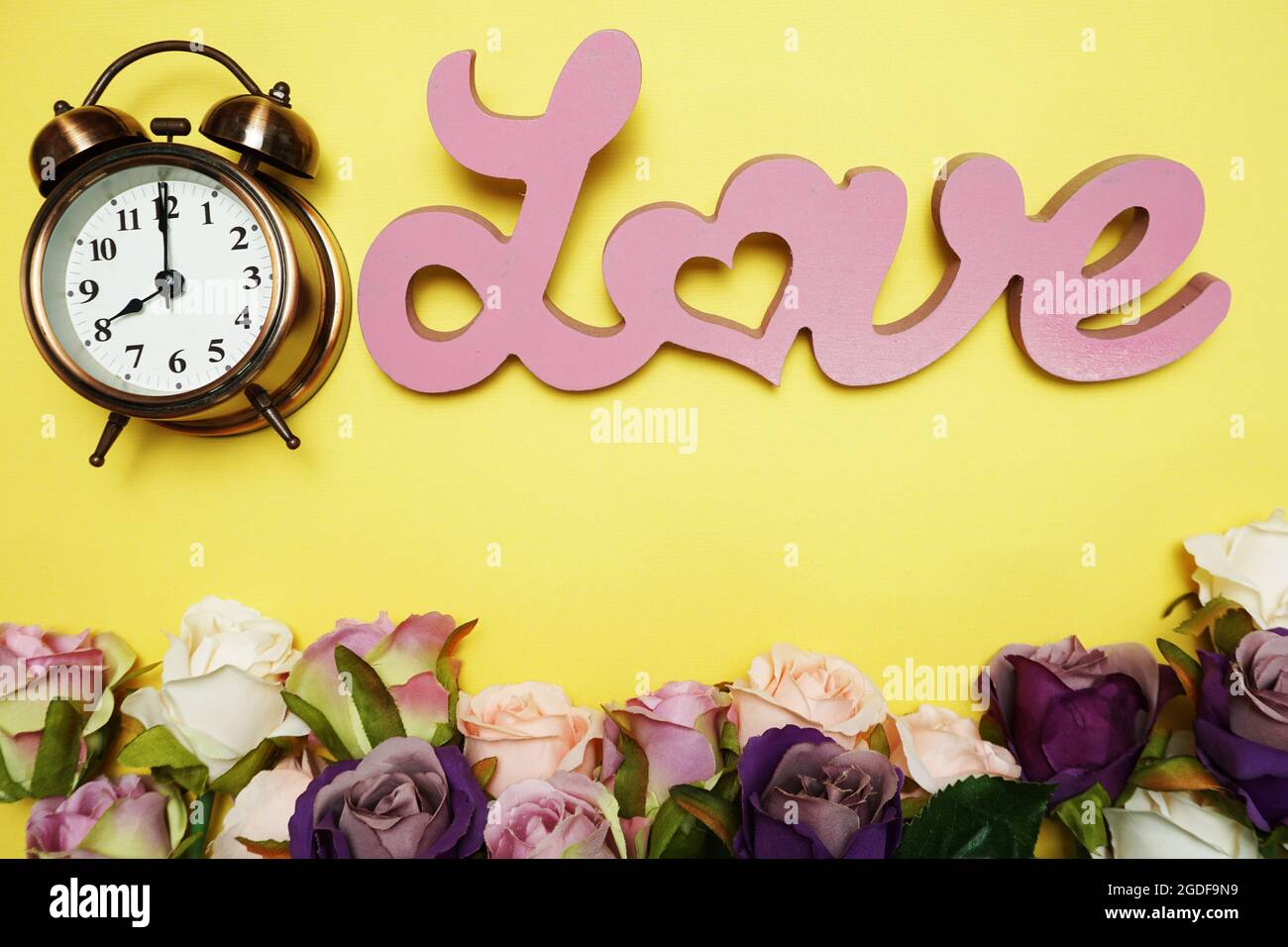 Love word alphabet and vintage alarm clock with roses bouquet with ...