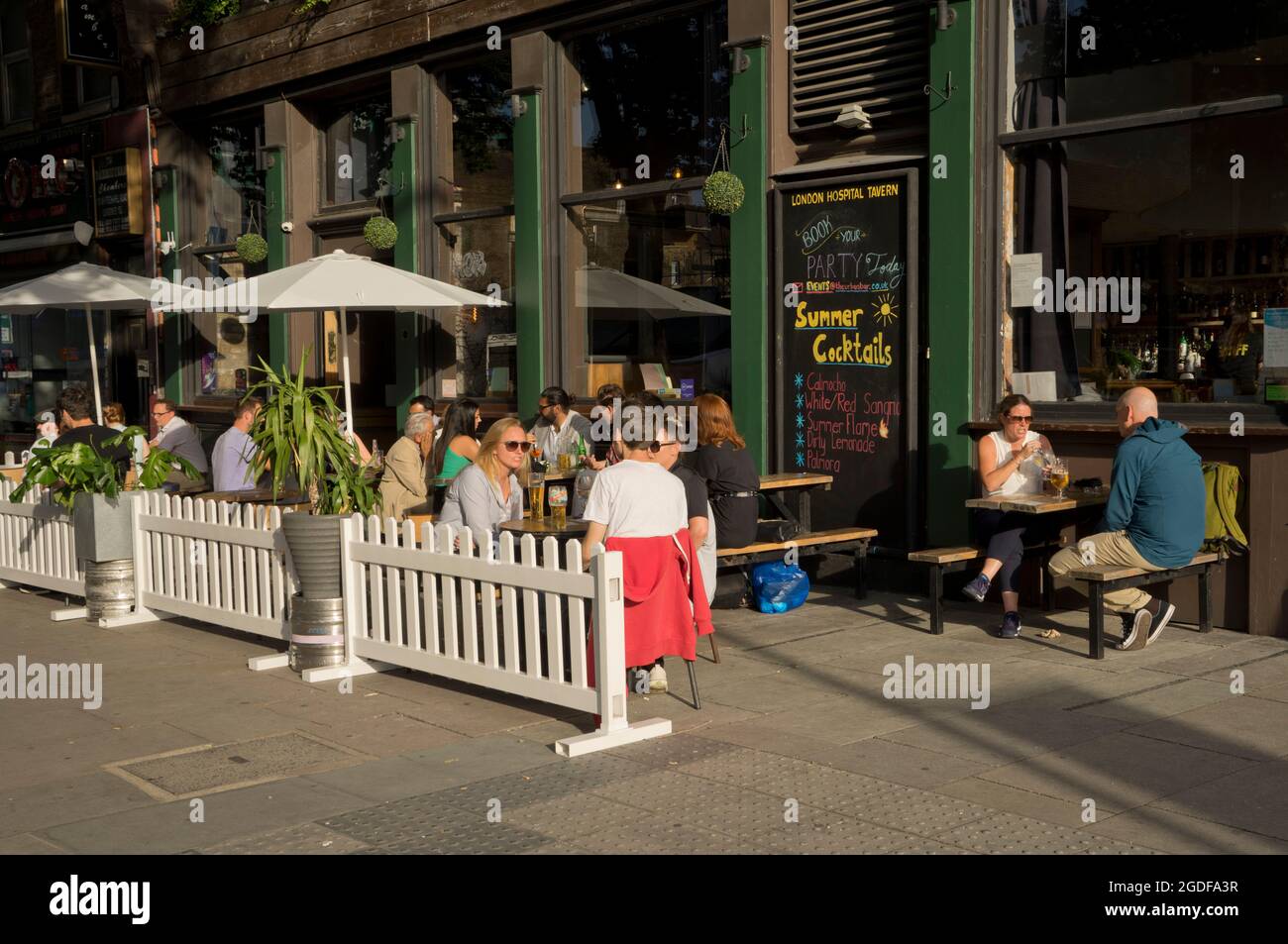 People sit outside a pub by the Royal London Hospital in Whitechapel ...
