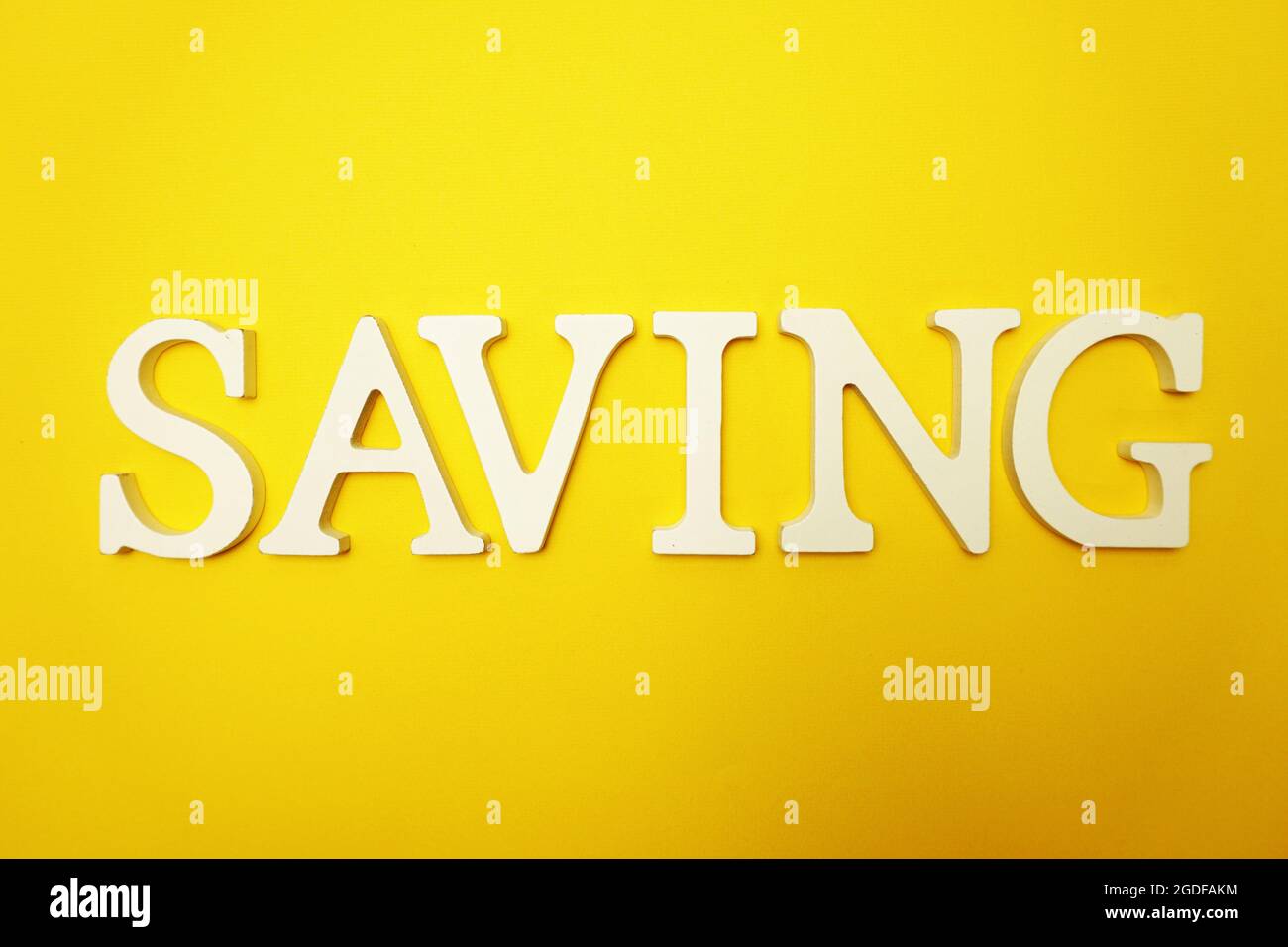 Saving alphabet letters on Yellow background Stock Photo - Alamy