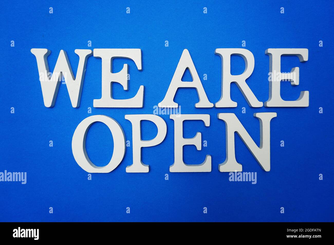 We are Open alphabet letters on blue background Stock Photo - Alamy