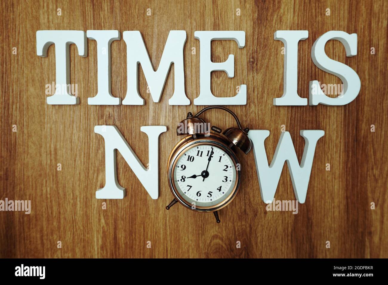 Time is Now alphabet letters with alarm clock on wooden background ...