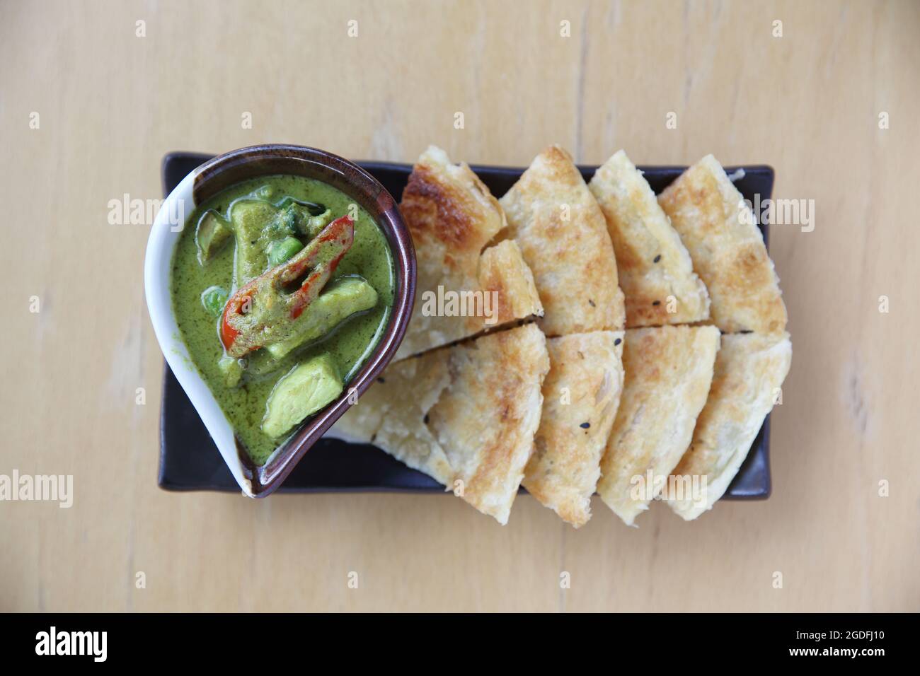 Roti with green curry on wood background Stock Photo - Alamy