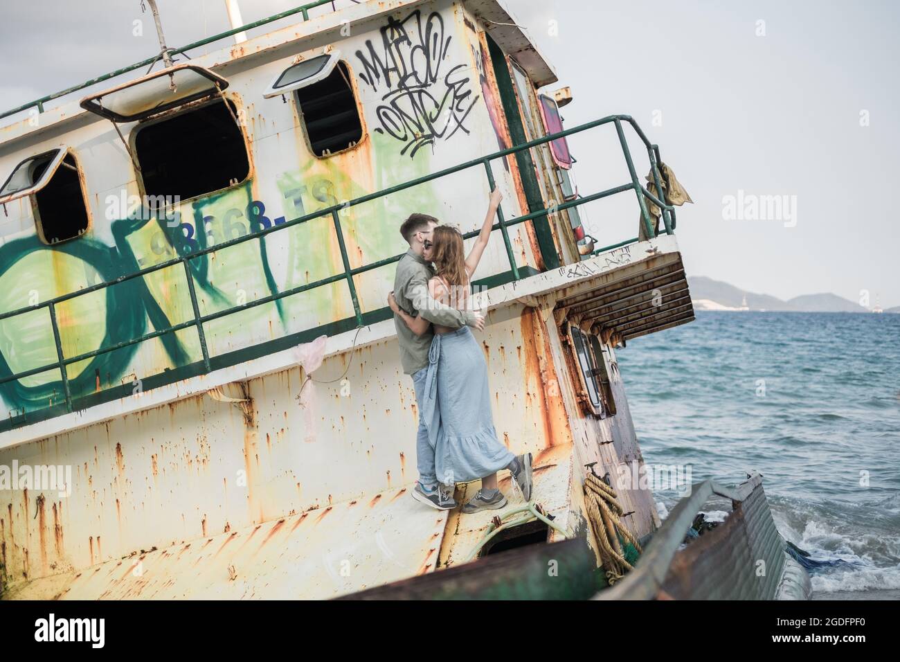 Picture of happy young couple in the old port with graffiti. Kissing ...
