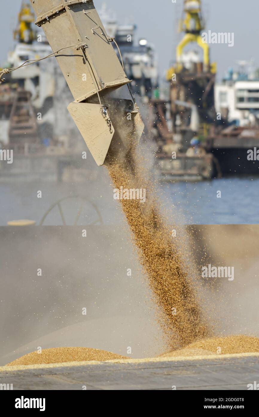 Vertical closeup of the sand being poured into a large metal container ...