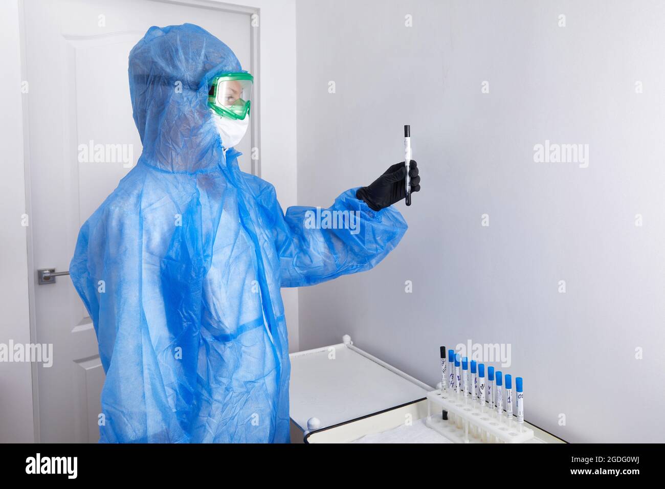 Medical healthcare technologist holding COVID-19 swab, wearing PPE ...