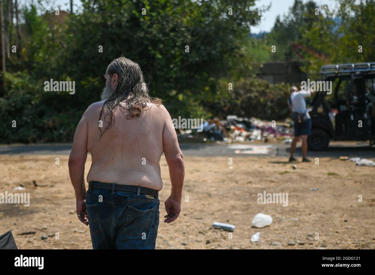 USA. 12th Aug, 2021. Southeast Portland resident Randy Rowland walks to ...