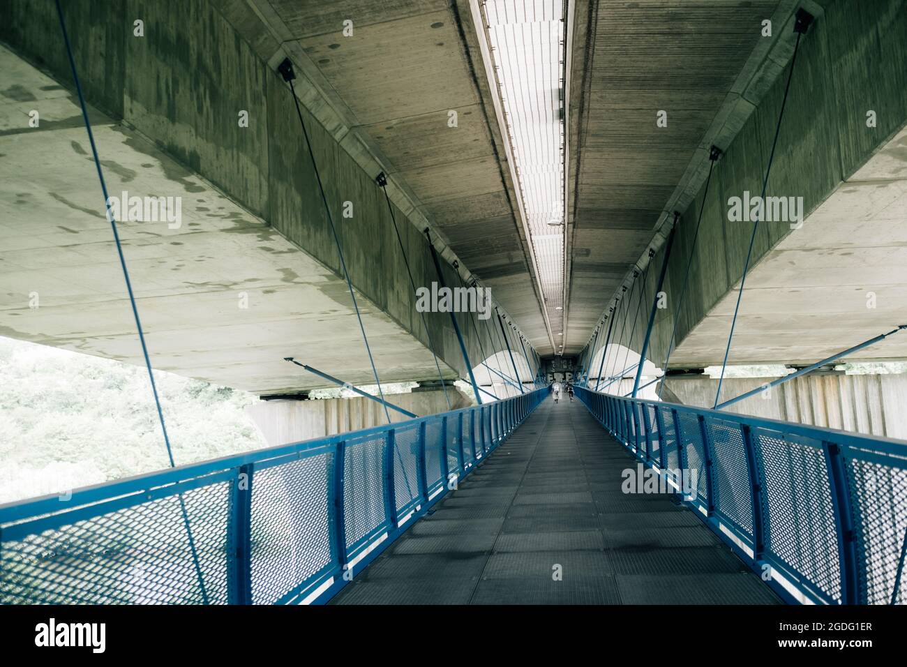Vertical shot of pedestrian bridge with concrete roof, metal grids and ...