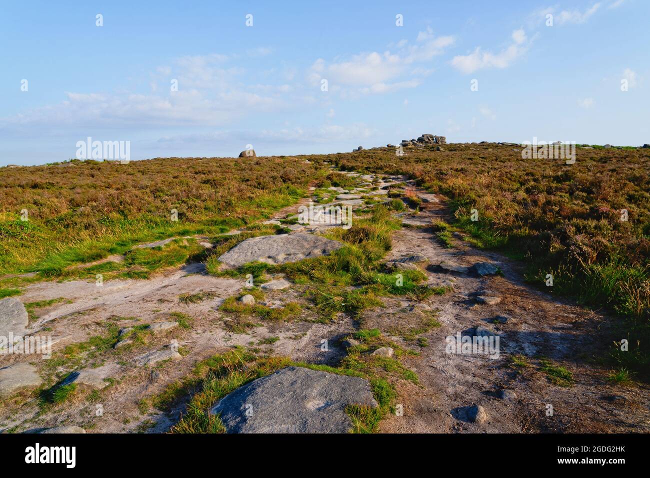 High in the Peak District a wide gritstone rock covered path rises up a ...
