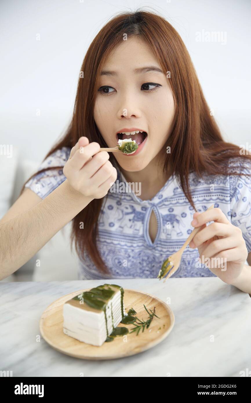 Young Asian Woman eating Green tea crape cake sweet food Stock Photo ...
