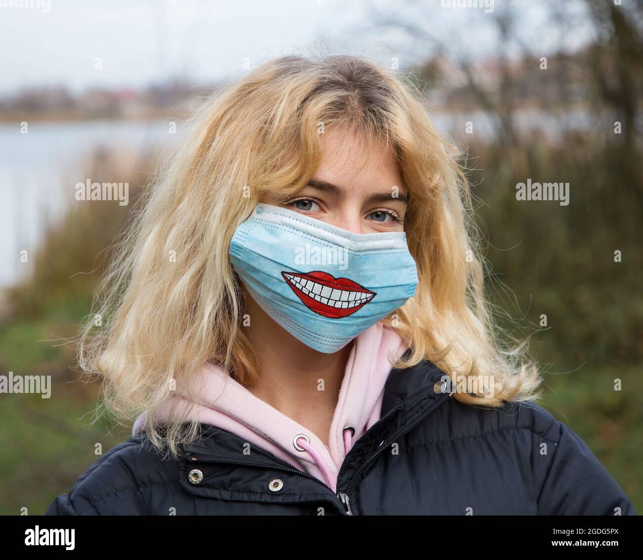 pretty young woman, a teenager girl in blue medical masks with a funny ...