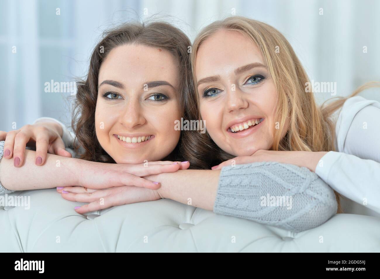 Beautiful young women hugging and looking at camera, friendship concept ...