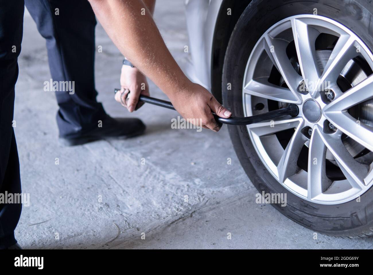Auto mechanic working removing a tyre from a car in a garage Stock ...