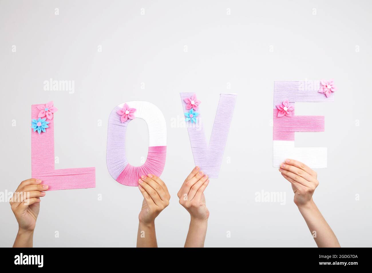 Hands holding up letters building word love on grey background Stock ...