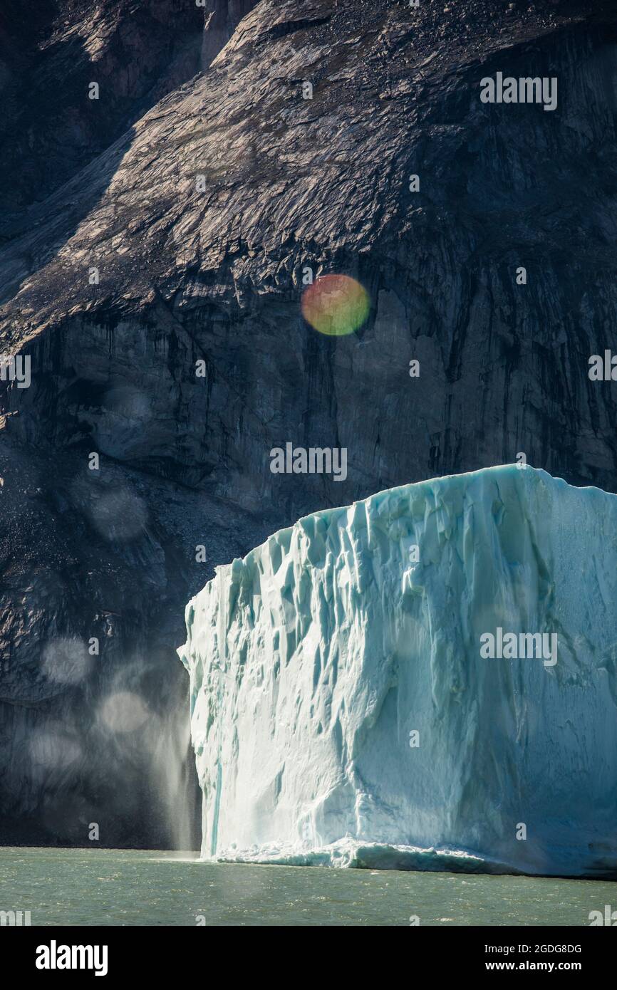 Scenic view of meting glacier against raw mountain cliff Stock Photo ...