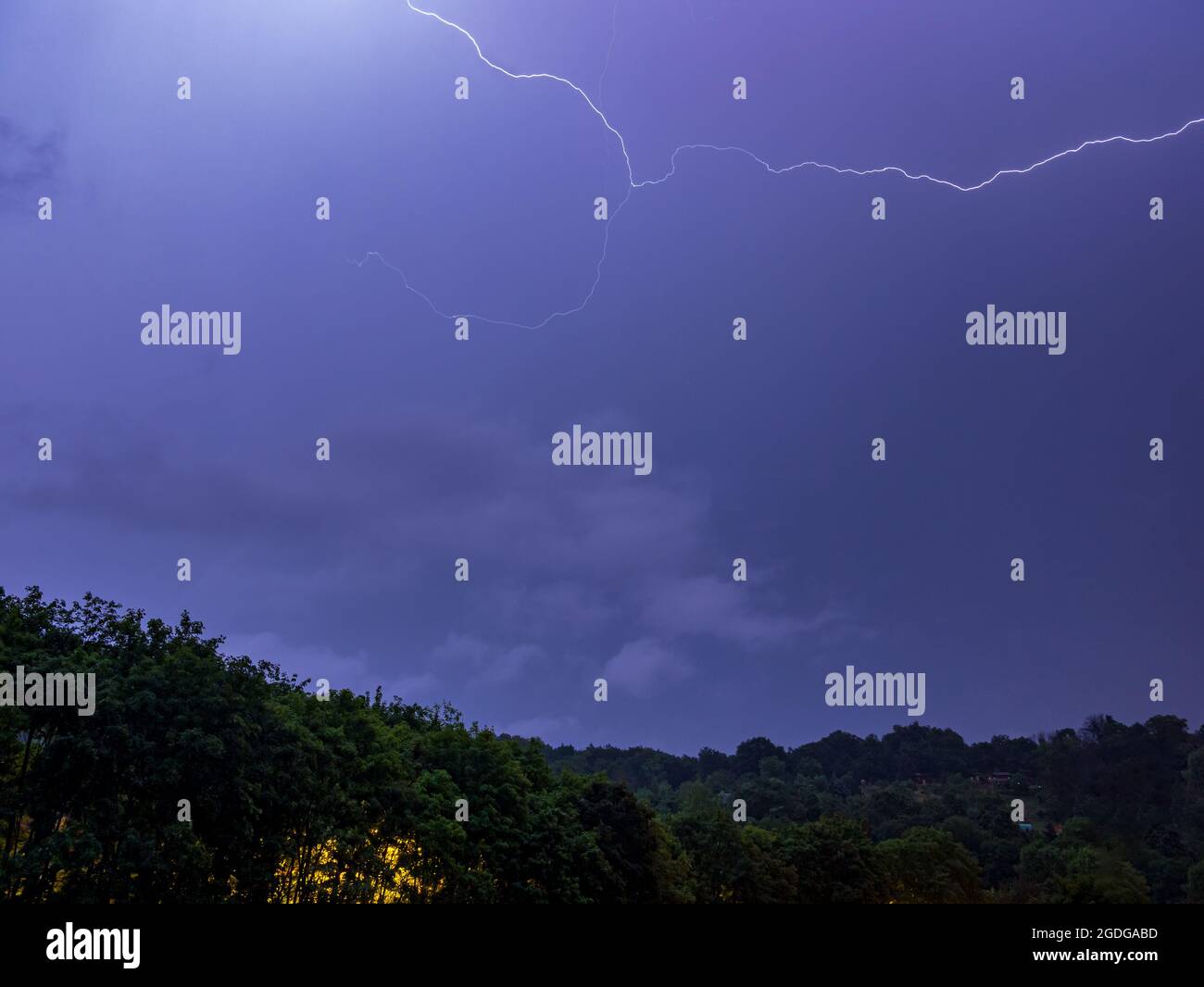 Lightning strike over a hill on the outskirts of the city - long ...