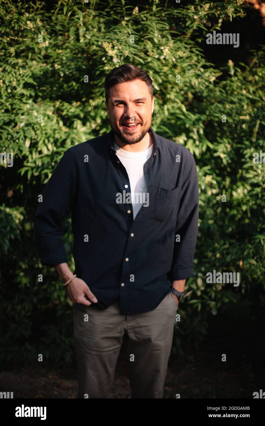 Portrait of happy man laughing standing in park during summer Stock ...