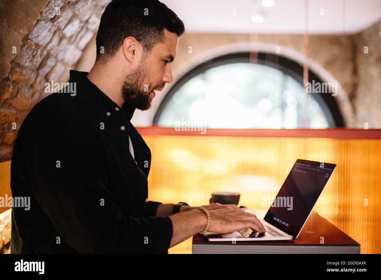 Concentrated man using laptop computer at cafe Stock Photo - Alamy