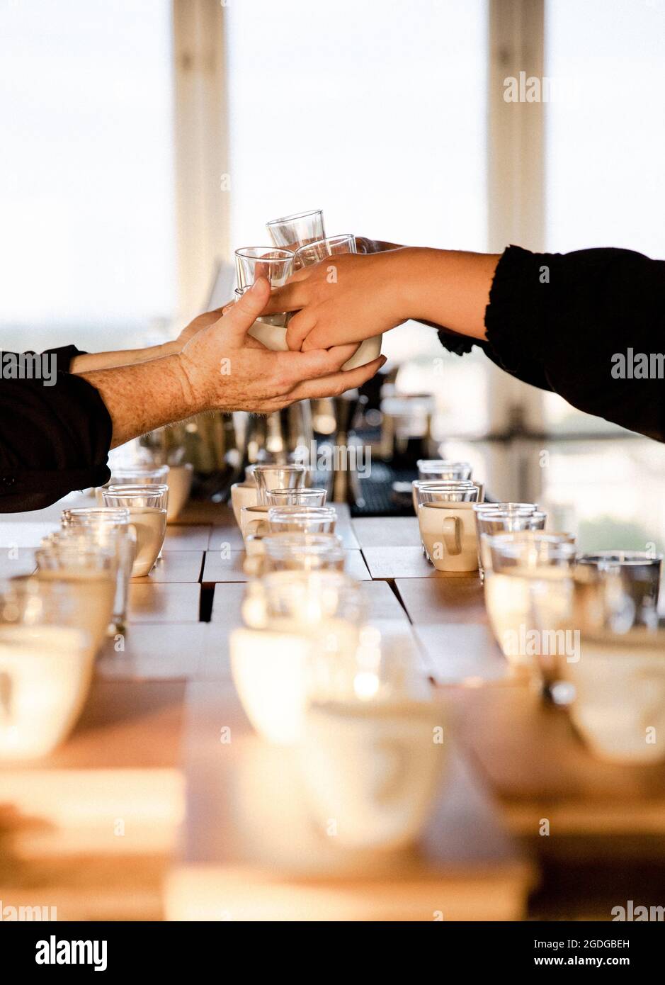 Bartenders Passing Glassware with Hands Stock Photo - Alamy