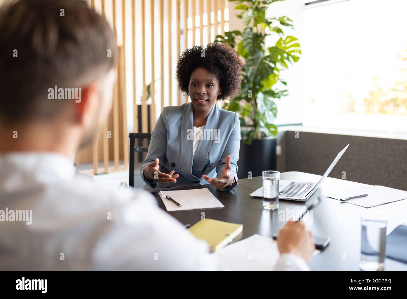 African American leader talking with new recruit during job interview ...