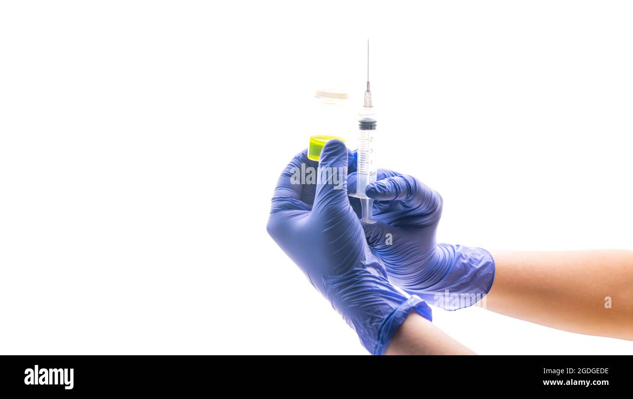 Doctor's or nurse hands in medical gloves holding syringe and bottle of ...
