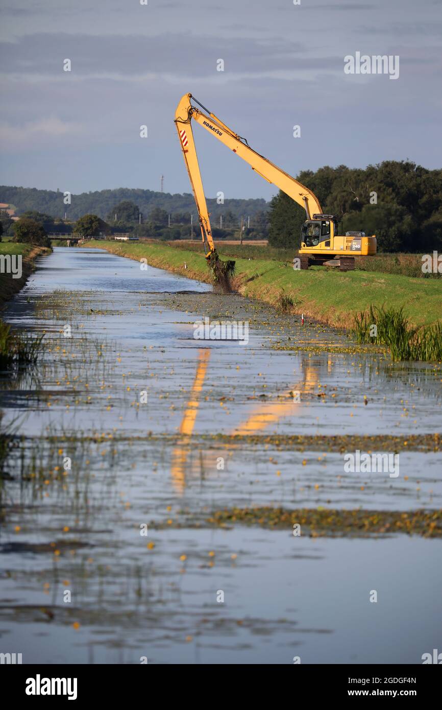 Holme, UK. 12th Aug, 2021. A Komatsu using a dredging basket being used ...