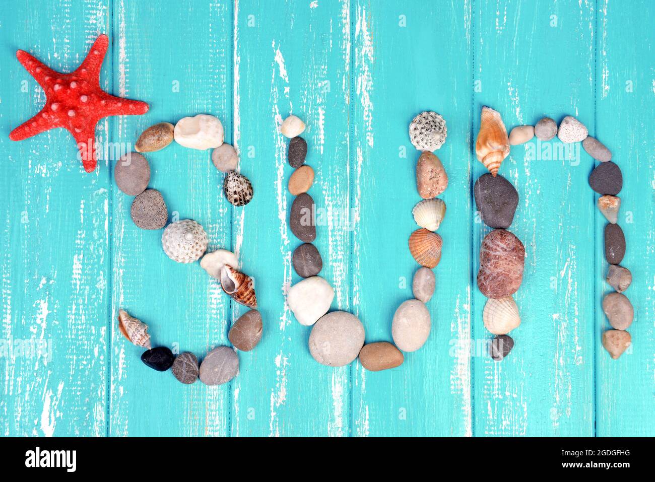 Word sun made from sea shells and stones on wooden background Stock ...