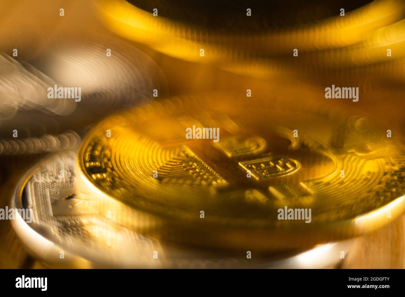 Closeup shot of gold and silver bitcoins scattered on a surface ...