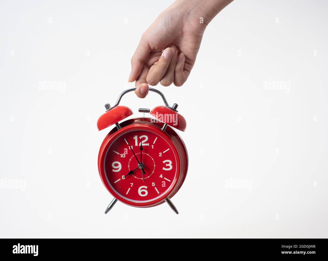 Female hand holding alarm clock on white background, copy space ...