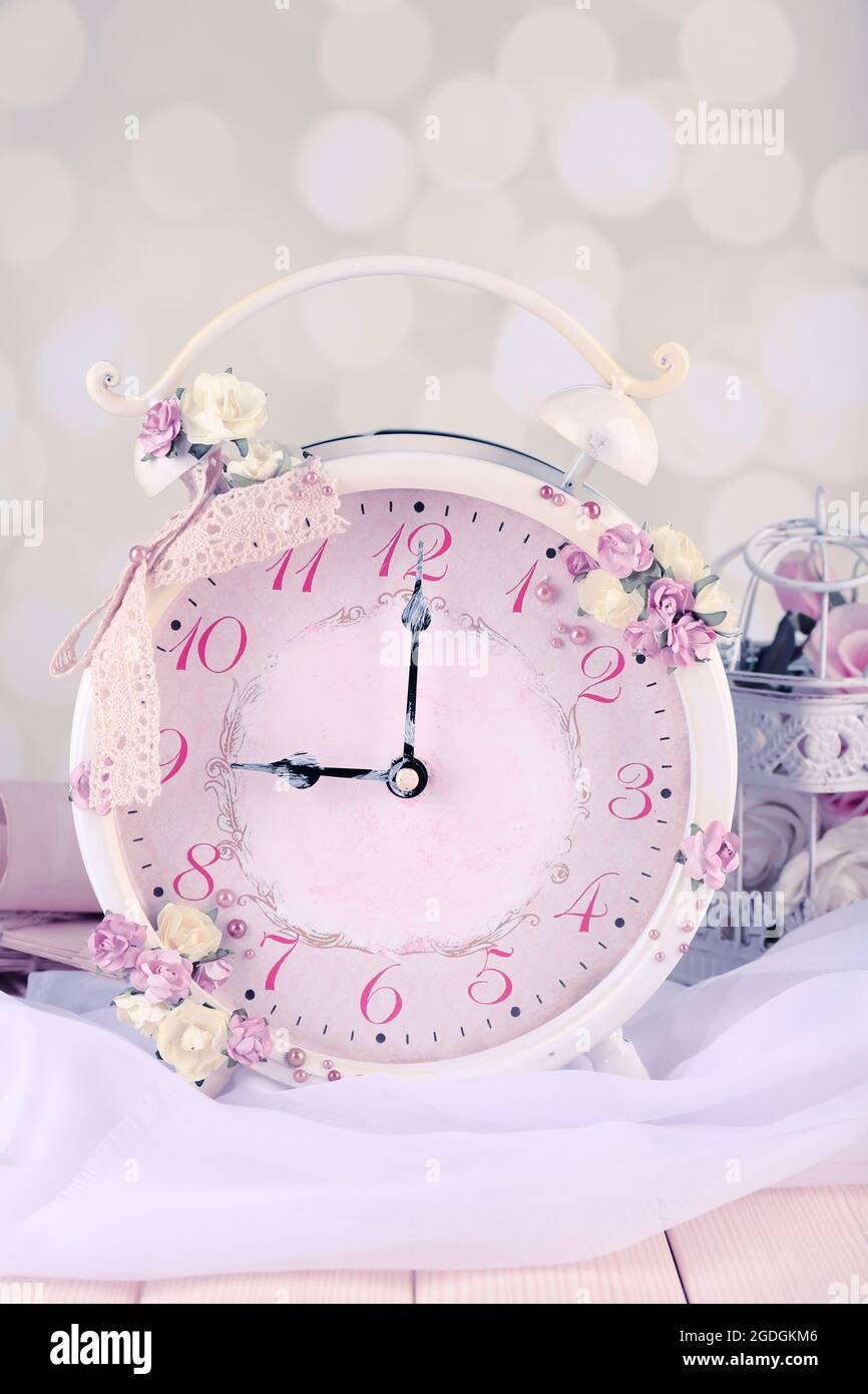 Beautiful vintage alarm clock with flowers on light background Stock ...
