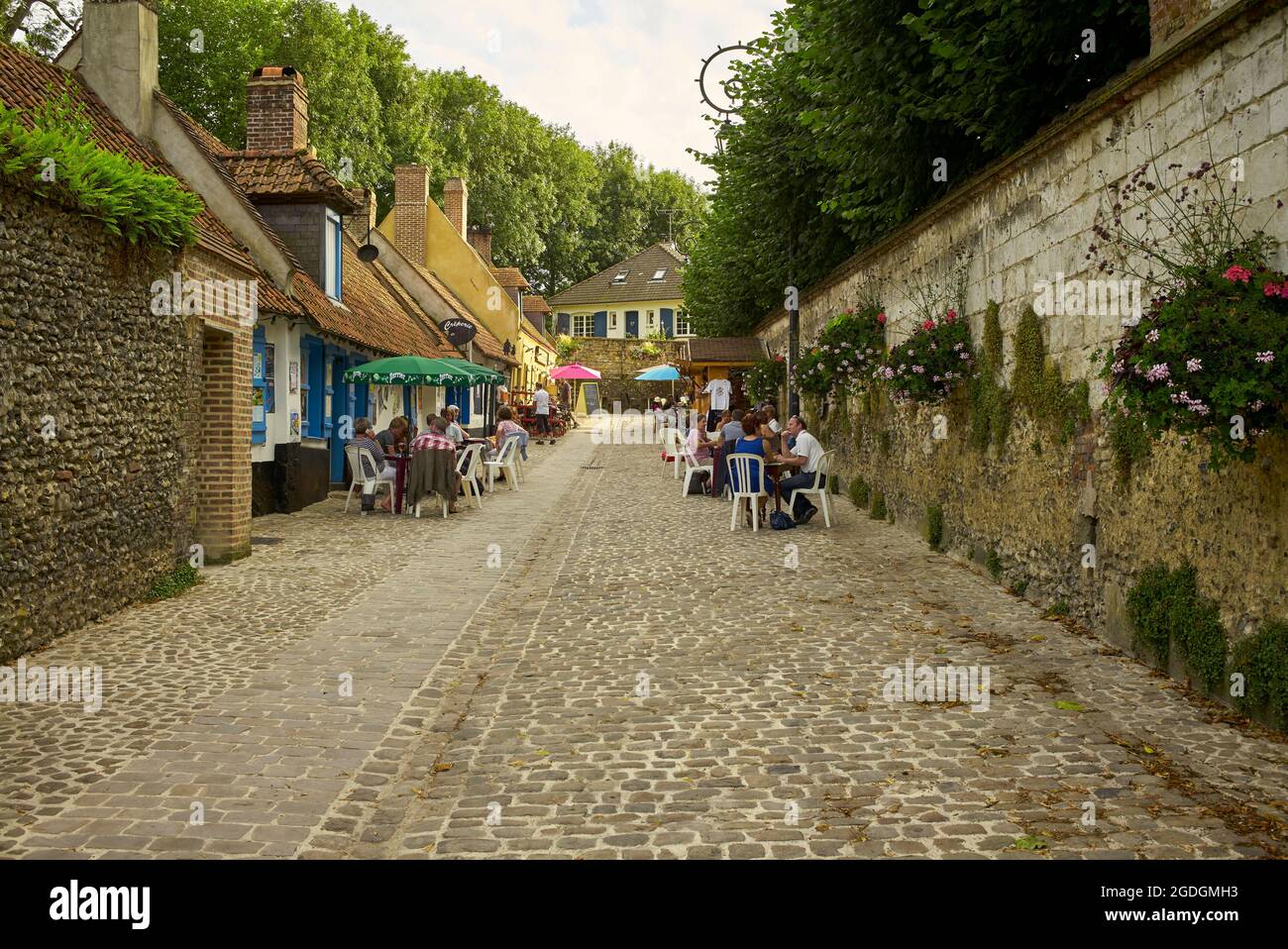 Tourists and locals sit outside a bar close to the ramparts of the ...
