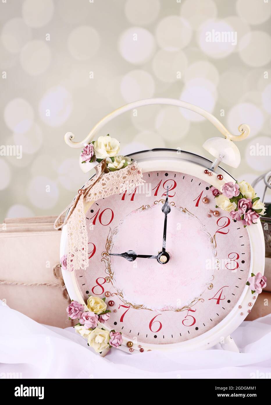 Beautiful vintage alarm clock with flowers on light background Stock ...