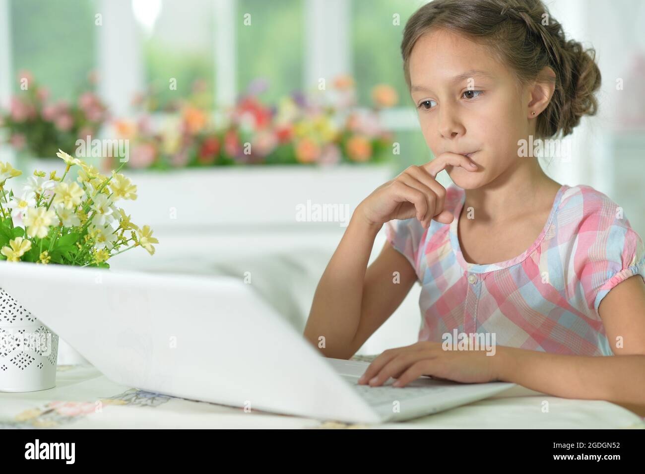 Thoughtful cute girl using laptop at home Stock Photo - Alamy