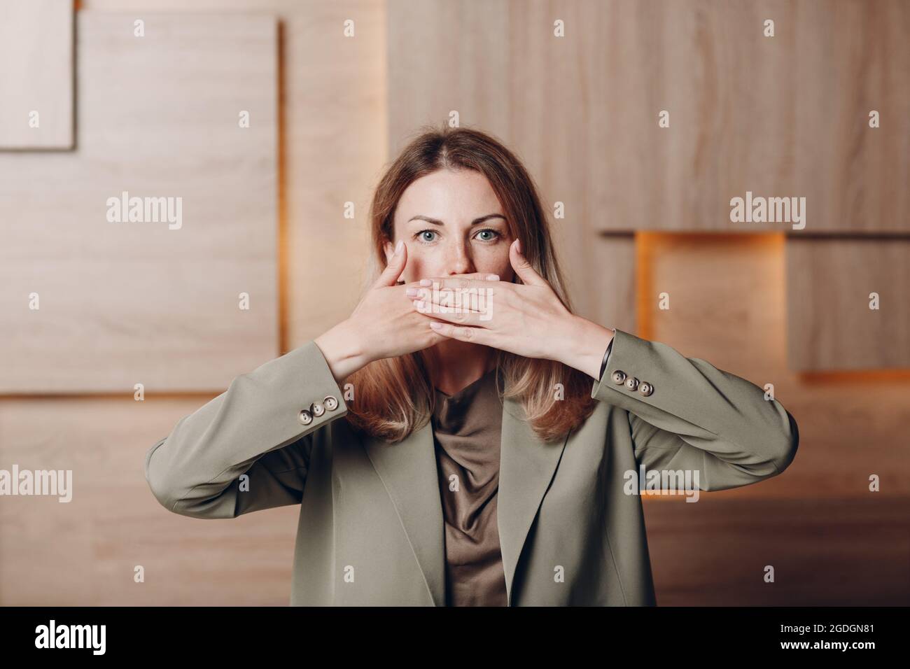 Business woman young adult coach at office close mouth with hands arms ...