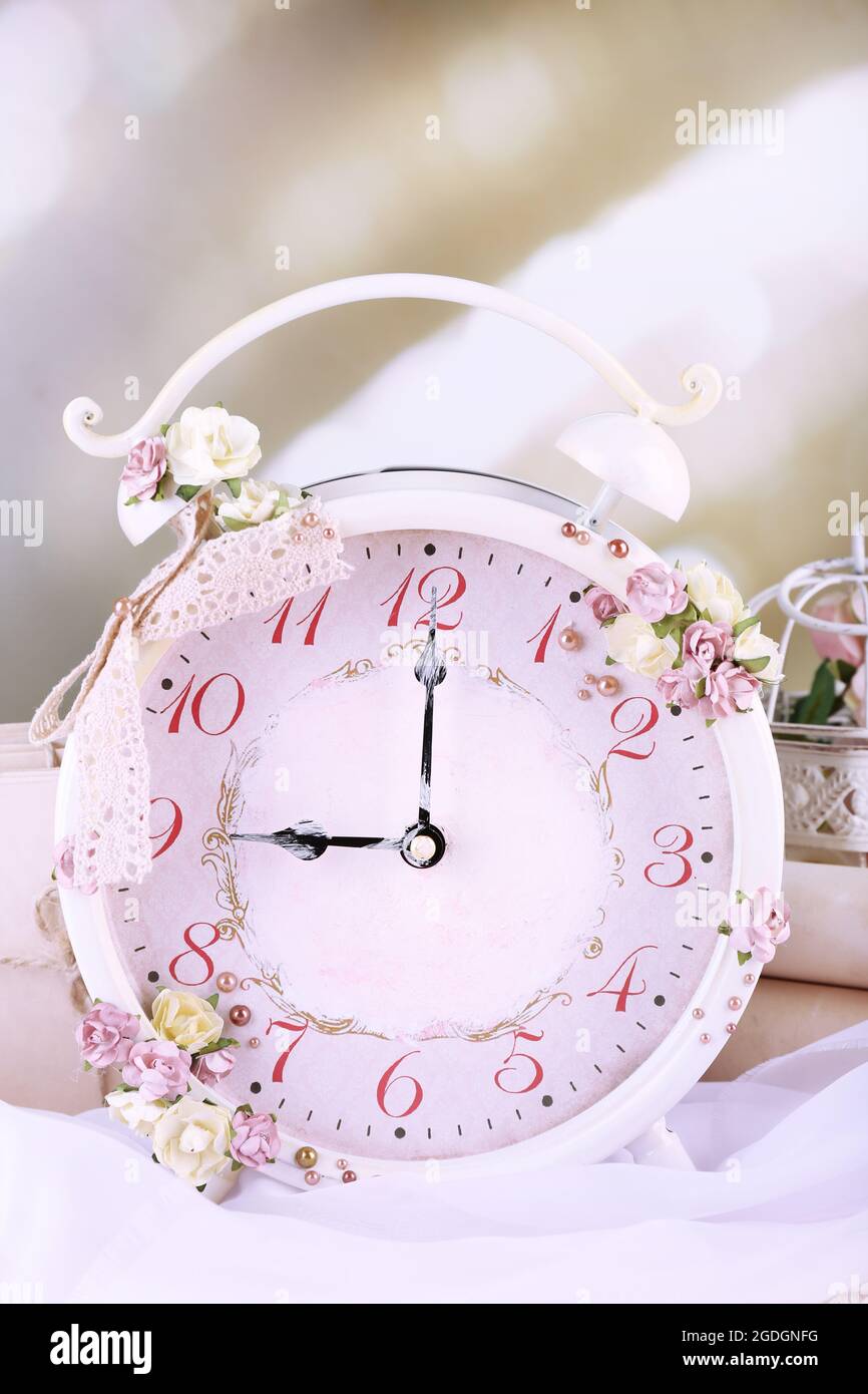 Beautiful vintage alarm clock with flowers on light background Stock ...