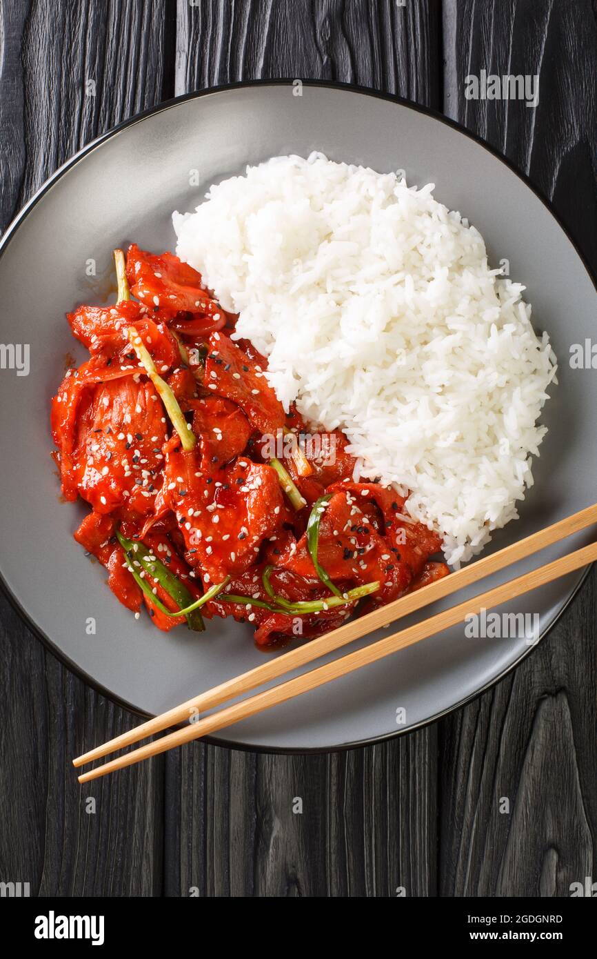 Jeyuk Bokkeum Spicy Pork BBQ with rice close-up in a plate on the table ...
