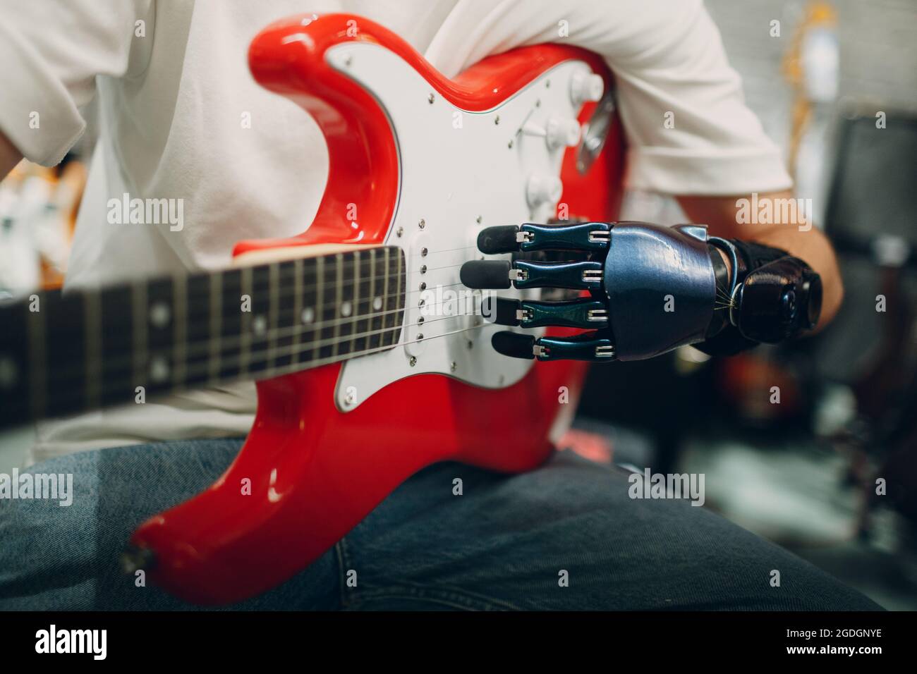 Young disabled man with artificial prosthetic hand close up plays on ...