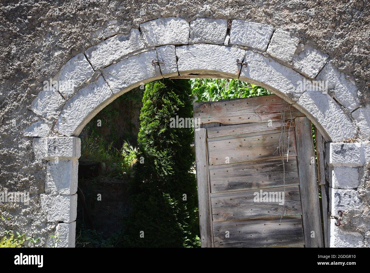Ancient stone arched entrance gate with an antique wooden door in ...