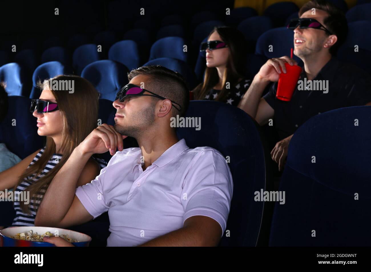 Young people watching movie in cinema Stock Photo - Alamy